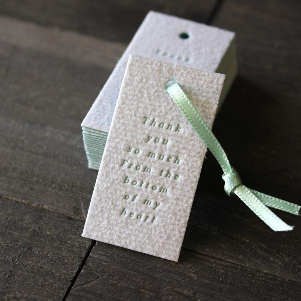 モコモコとした手触りのグレーの起毛紙に活版印刷で制作したサンキュータグです。裏地には印刷カラーと同系色でクロコ調のテクスチャがユニークな紙を貼り合わせております。紙質と活版印刷特有の凹んだ文字がとても個性的なタグに仕上がっております^^プレ...