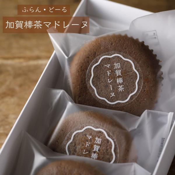 上林金沢茶舗さんのの加賀棒茶を石臼で丁寧に挽き、しっとりとしたマドレーヌ生地に練り込んでいます。食べると棒茶の風味がお口いっぱいに広がります。マドレーヌの中には国産の大粒黒豆が3粒アクセントとして入っています。金沢土産に最適！