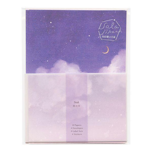 夜明けから真夜中、１日の始まりから終わりまでの空を水彩で描いた「空時間の手紙」のレターセットシリーズ。手紙を書くときの時間や気持ちに合わせて色とりどりの空を楽しめます。宛名ラベルと紙飛行機形の封かんシールに、太陽や星の光をイメージしたキラキ...