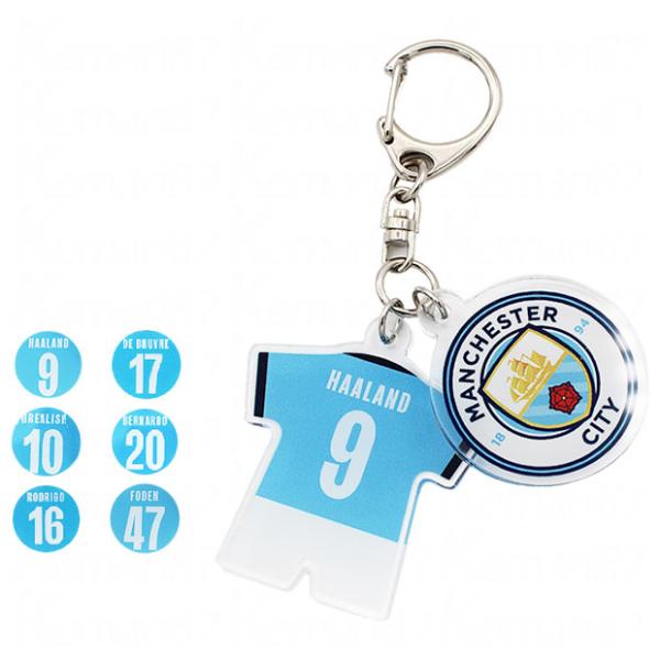 イングランド・プレミアリーグの名門、マンチェスターシティ、キーホルダー。定番のサポーターズアイテム。ネーム &amp; ナンバー入りユニフォーム型チャームとエンブレムチャームの2連仕様。素材：アクリル、金属サイズ：F(フリー)カラー：スカイ...