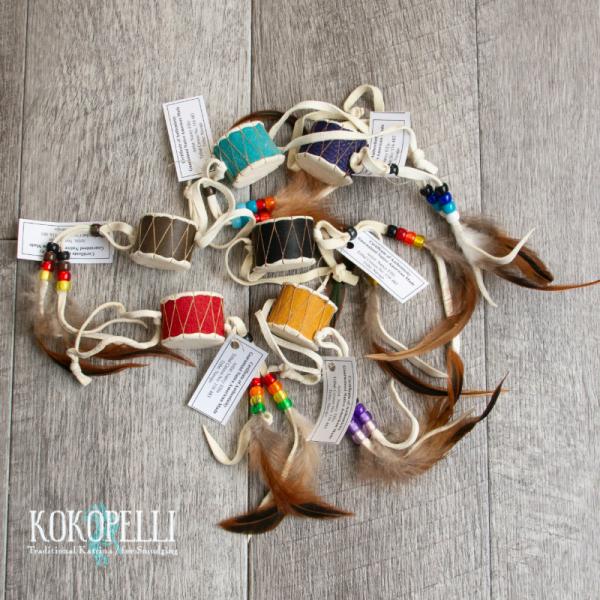 ■ドラムサイズ:4×4×3cm■長さ:約38cm■制作者:Nancy Ellis(Navajo)■素材:本革、人工シニュー、ビーズ（プラ）、羽（鶏）ナヴァホ族制作のミニチュアドラム。音は出ません。革張りでシニュー(腱)で編んでいます。キーホ...