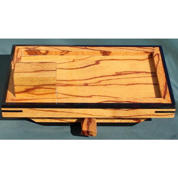 木目の中に、特徴的な横縞「大理石豆木御膳」です。明るい色彩の予想とは違って木質は硬く、重量感がございます。模様は木材というよりも石像に使う石材のようで、秋のこない天然の良さが光ります。角木を保護するためのゴム板２枚と袋も付属しております。　...