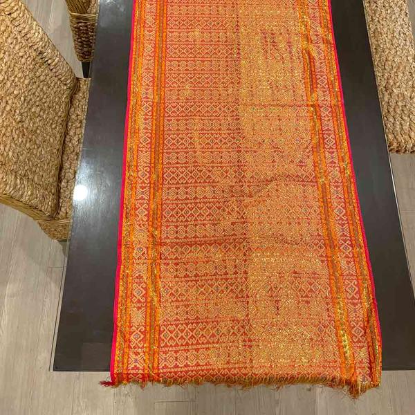 バリ島製　テーブルランナー、タペストリーなど、多用途にどうぞアジアンテイストな空間を演出するファブリックとして欠かせないアイテムであるイカットは縦糸と横糸から編まれる布です。明るい色合いで金糸使用のキラキラと光る華やかなタイプをセレクト。ダ...