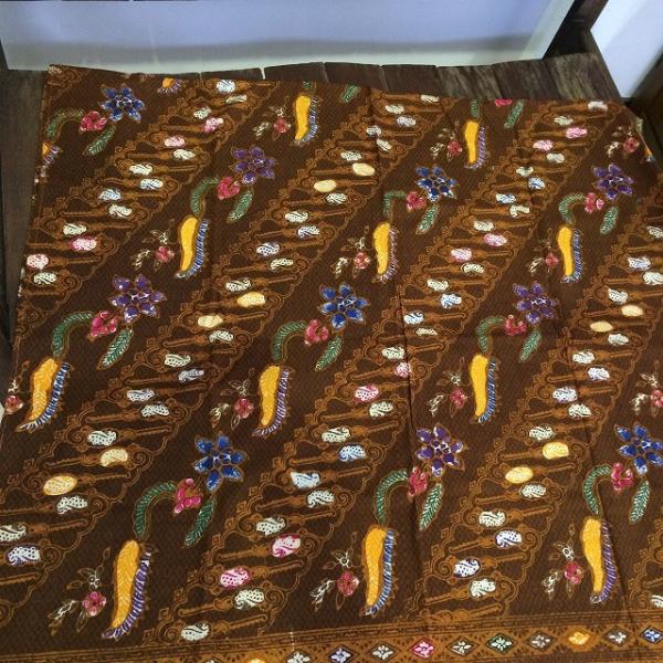 落ち着いた茶色に、カラフルな花柄が映えた、バティック。パイナップル繊維入りのバティック（ろうけつ染め）。綿よりもさらっとした手触りです。カーテン、テーブルクロス、各種カバーなど、多用途にご利用いただけます。　※多少のサイズのズレや模様の崩れ...