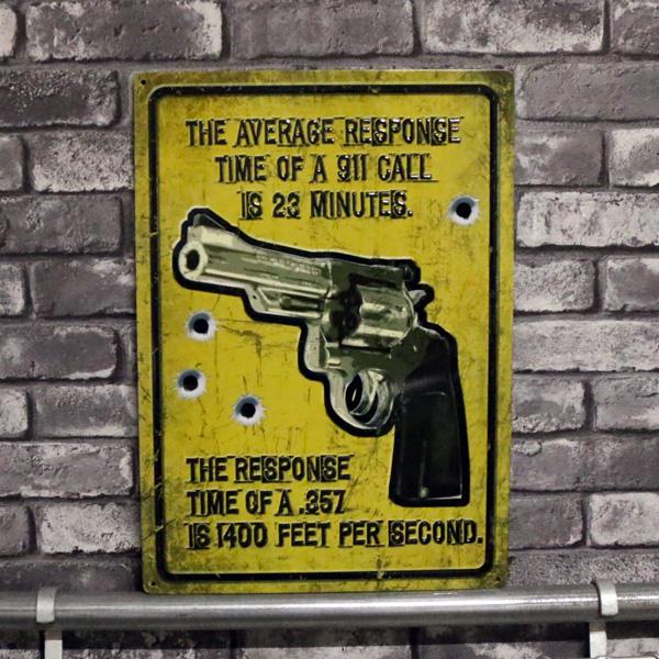 ヴィンテージ調のヨゴシをテクスチャに加えたイエローのベースに大型のリボルバー銃をレイアウトした派手なメタルサイン。テキスト部分と銃のイラスト部分はエンボス加工されており、立体的な面白味もあります。 銃痕の穴は実際に穴が開いている凝ったデザイ...