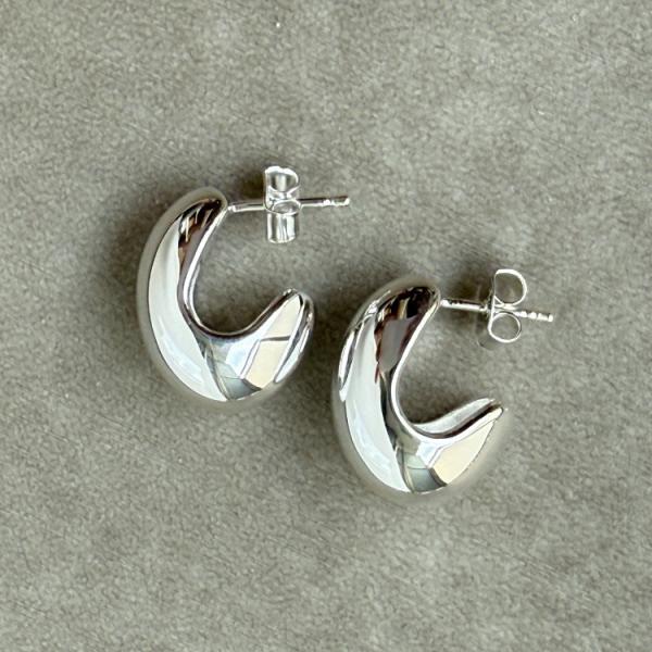 なめらかな曲線と程よいボリューム感が、顔まわりに垢抜けた印象を与えてくれます。ミニマルながら艶やかな表面が光を美しく反射し、上品なアクセントとなります。オン・オフ問わず、どんなシーンにも溶け込むデザインで、ひとつあると重宝するアイテムです。...