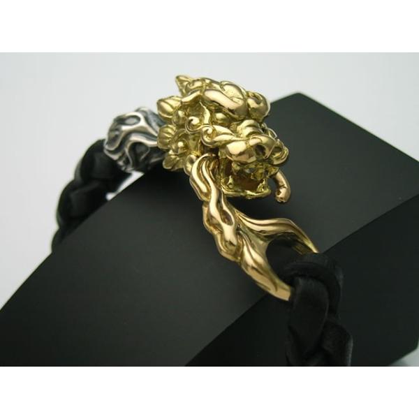 大胆な彫刻が施された狛犬のブレスレット。留め具にはフレアの彫刻があり、６枚のフラップがレザーをガッチリと咥えています。5mm巾の革を一本一本手で四編みしています。レザー部分は使い込むと「アメ色」に変色し、良い味が出ます。素材：K18 （１８...