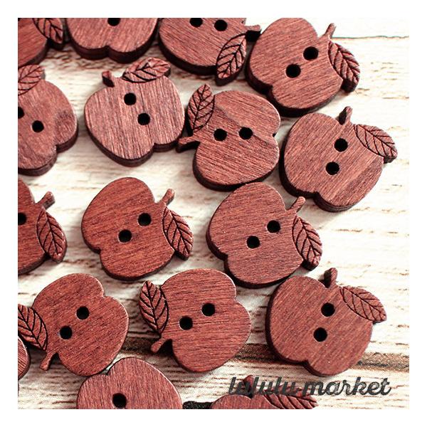 りんごの形の木製ボタン15個セット。木目が入った、少し赤みのあるブラウンです。縫い付けにも貼り付けにも、お子様の工作などにもおすすめです。お買い得な100個セットも販売中です。■サイズ：高さ約15mm×幅約17mm×厚み約4mm／穴約2mm...