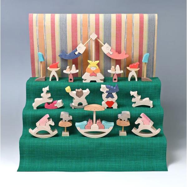 武者姿の童子、金太郎とその仲間の動物たちのほかに、この作品に登場する木馬、シーソー、スケートボードは、男の子が遊びの中で体を鍛える道具の象徴として用いています。全部で59片の木片を三つの円形容器に収納することが遊びとなります。 垂れ幕の色（...