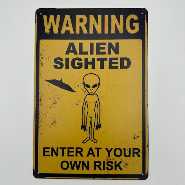 エイリアンとUFOが描かれた警告サイン風のブリキ看板です。縦30cm、横20cmのサイズで、お部屋や店舗のユニークなアクセントにぴったりです。「WARNING ALIEN SIGHTED ENTER AT YOUR OWN RISK」という...