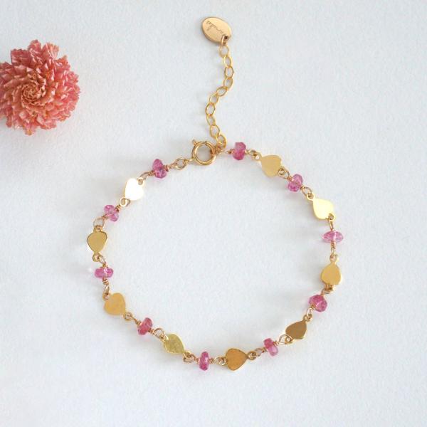 カッティングの入ったピンクトパーズとハートのプレートが交互に飾られたブレスレットです。石の合間に飾られたゴールドのハートがキラッと輝く可愛いデザインです。全ての金具にはゴールドフィルドを使用。高級感があり、金属アレルギーの方にも大変人気の素...