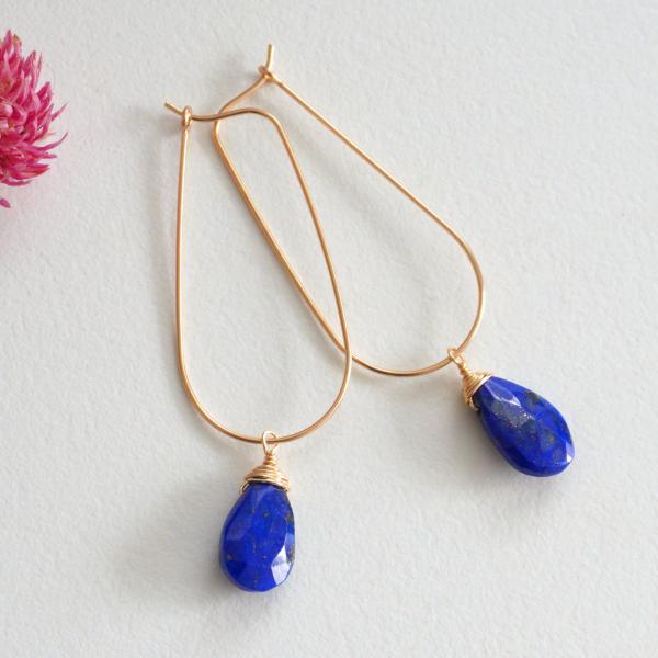 ゴールドのワイヤーで作られたロングフープに一粒のラピスラズリが揺れるピアスです。ラピスラズリはカッティングが美しく光に反射して輝きます。全ての金属にはゴールドフィルドを使用。高級感があり金属アレルギーの方にも大変人気の素材です。【サイズ】 ...