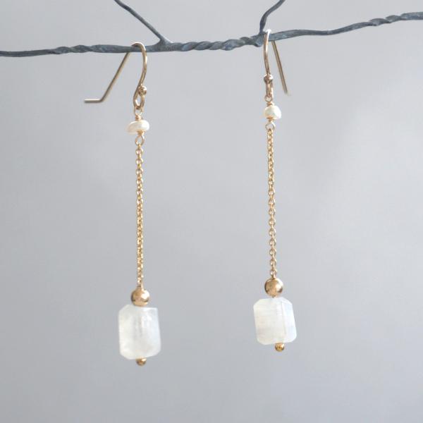 小さなパールが飾られたチェーンの先にランダムにカットされたレインボームーンストーンが揺れるピアスです。レインボームーンストーンは光の反射や角度によってシラーが美しく輝きます。全ての金属にはゴールドフィルドを使用。高級感があり金属アレルギーの...