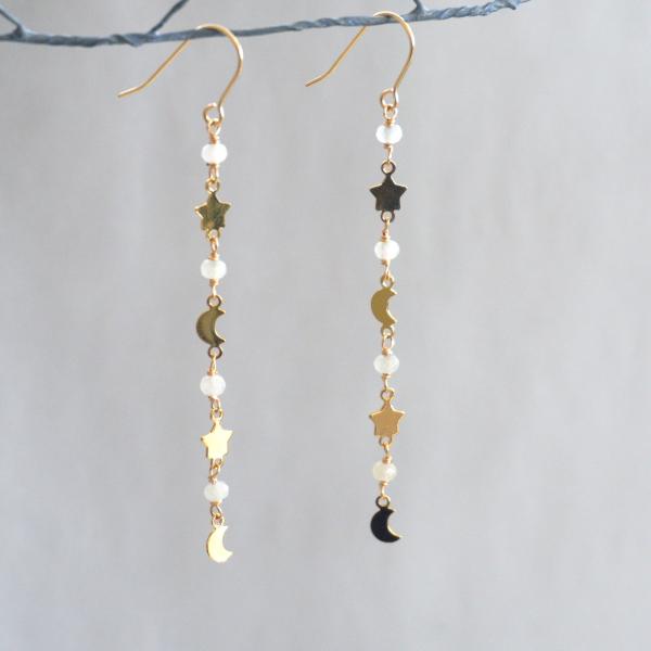 カッティングの入ったホワイトジェードと月と星のプレートが飾られたロングピアスです。石の合間に飾られたゴールドの月と星がキラッと輝く可愛いデザインです。全ての金具にはゴールドフィルドを使用。高級感があり、金属アレルギーの方にも大変人気の素材で...