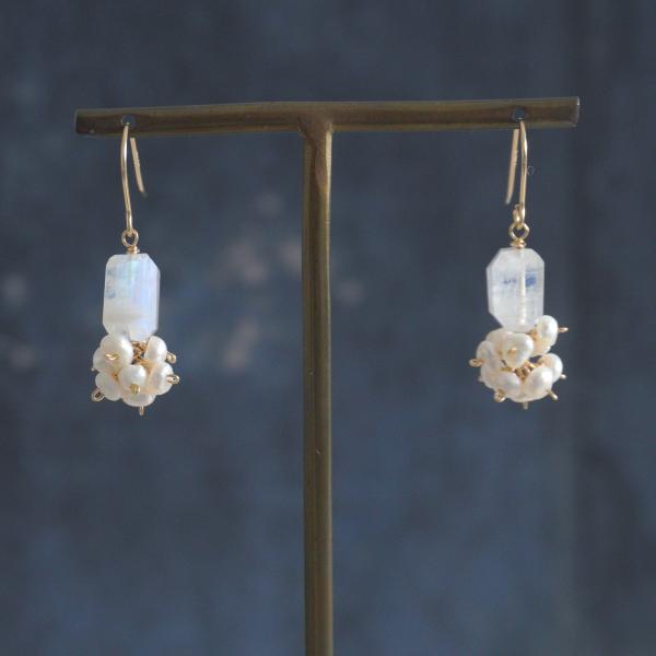 レインボームーンストーン下に淡水パールのつぶつぶが飾られたピアスです。レインボームーンストーンは角度によってシラー(青白い光)が見られる神秘的な天然石です。全ての金属にはゴールドフィルドを使用。高級感があり金属アレルギーの方にも大変人気の素...