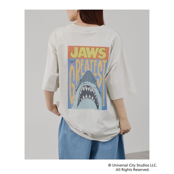 「JAWS」のプリント半袖Tシャツです。カラーは、オフホワイトです。■デザインバックに印象的なグラフィックをあしらった存在感のあるデザイン。古着調のボディカラーとプリントが、レトロな雰囲気を演出します。■ポイント綿100％のOE天竺素材を使...
