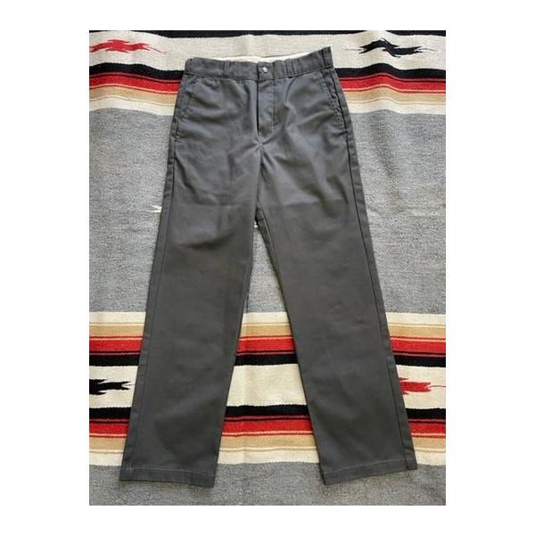 ポリエステル65%、コットン35%の混率で織り上げた頑丈なツイル生地を使用したワークトラウザース。生地は肌触りの良さに加えシワになりにくく、特有の光沢感が特徴。TUF-NUTのヴィンテージトラウザースは尿素ボタン仕様のものが多くみられるが、...