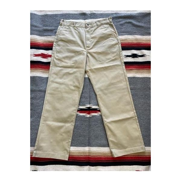 ポリエステル65%、コットン35%の混率で織り上げた頑丈なツイル生地を使用したワークトラウザース。生地は肌触りの良さに加えシワになりにくく、特有の光沢感が特徴。TUF-NUTのヴィンテージトラウザースは尿素ボタン仕様のものが多くみられるが、...