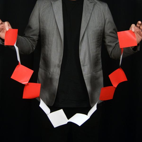 1枚の紅白の紙をバラバラに切りますが、各々の角が一連に繋がり、再びバラバラにして繋いでみせます。