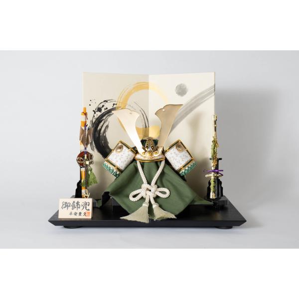 伝統工芸の価値をみる確かな目と決め細やかな演出を大事にする平安豊久の兜飾り。美しい萌葱色の兜。左右の吹返しは蜻蛉の印伝を施した個性的な兜です。飾り台は艶の無い木目の黒に和紙屏風の組み合わせ。筆で墨を使って円を描いた迫力のある和モダンなデザイ...