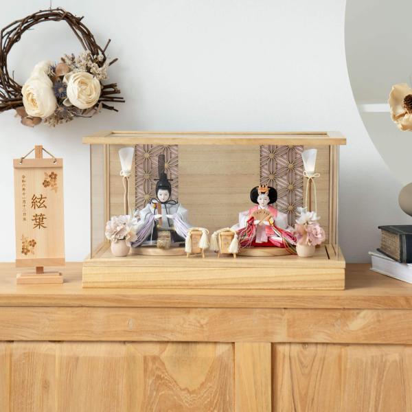 江戸時代から続く最古の老舗、「顔がいのち」で有名な吉徳大光のお人形。顔は現代風の優しい顔で目がぱっちりしており、全体的にはっきりとしています。衣装は松皮菱文様の京都西陣織、薄いグレーとピンクの組み合わせ。肩や袖、姫の裾幅がきっちり揃っている...