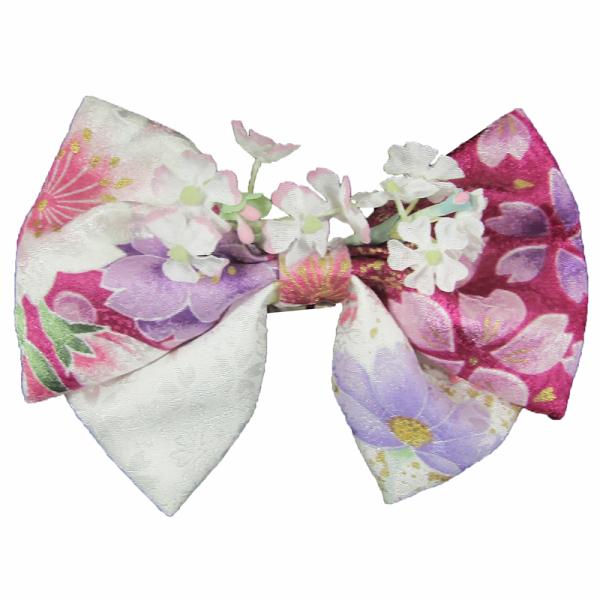サイズ縦 約10cm 横 約12.5cm造花の飾りが付いた和柄生地のリボン髪飾りです。髪を留める部分には、パッチン留めとも呼ばれるスリーピンを使用しています。★光の加減により写真の色と実際の商品の色が異なることがあります。