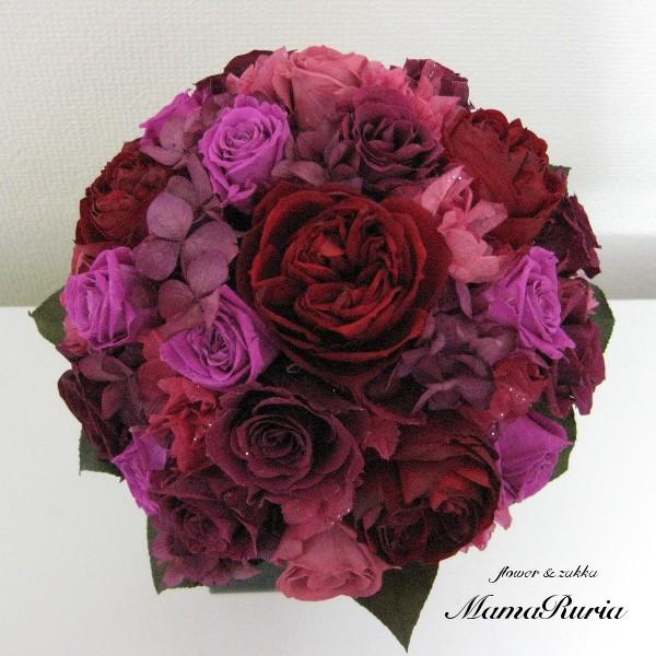ウェディング用ラウンドブーケ（レッド・パープル系）です。当店では１つ１つ丁寧に手作りしたブーケをお届けしております。ブーケスタンド・ブトニア付きのお値段です。「プリザーブドフラワー（約2/3）」と「アーティフィシャルフラワー（約1/3）」を...
