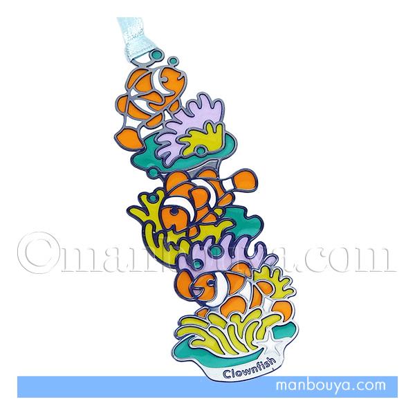 クマノミデザインのステンレス製ブックマーカー。本などに挟んで目印にする、しおりです。オレンジ色のクマノミと、ふわふわとしたイソギンチャクが華やかなデザイン。色の部分は半透明のステンドグラスタイプになっています。お洒落で可愛いブックマーク。プ...