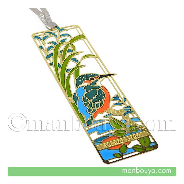 カワセミデザインのブックマーカー。本などに挟んで目印にする、しおりです。カワセミの背中の青とお腹のオレンジ、水や葉の部分は半透明のステンドグラス風。絵柄の無い部分は型抜きされています。ブルーグリーンの羽色に金色のフチがとても綺麗。少し大きめ...