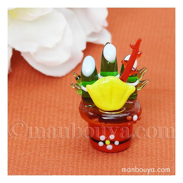 とても小さい硝子細工の門松です。梅模様がついた赤い鉢に3本の竹。扇子や枝もついて、おしゃれで華やかです。干支の置物や鏡餅、羽子板などと組み合わせてお正月の飾りに。【サイズ】約高さ3.5×直径1.8cm※ごく小さい商品です。画像の大きさのめや...