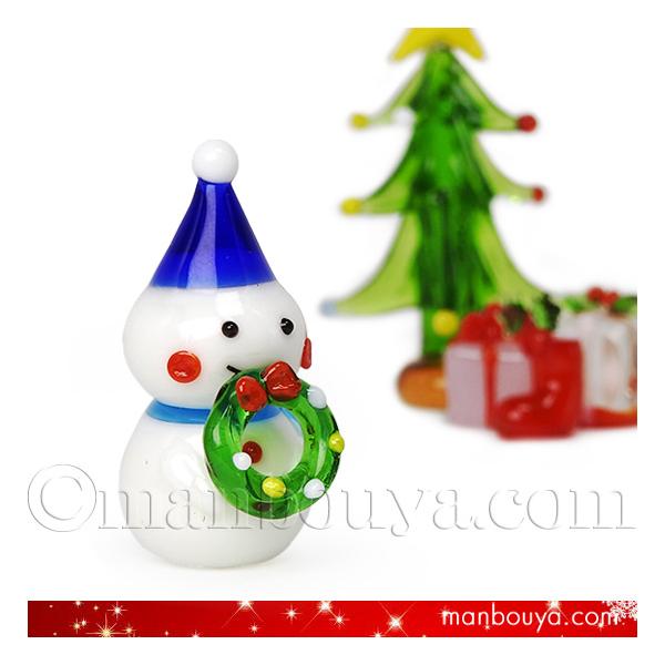 冬のインテリア雑貨。小さいゆきだるまのガラス製オーナメント。青い帽子とマフラー、クリスマスリースを持ってにっこりとした表情がかわいい置物です。ガラス細工の中では比較的大きいサイズなので、ひとつだけでも存在感があります。クリスマスツリーなどと...