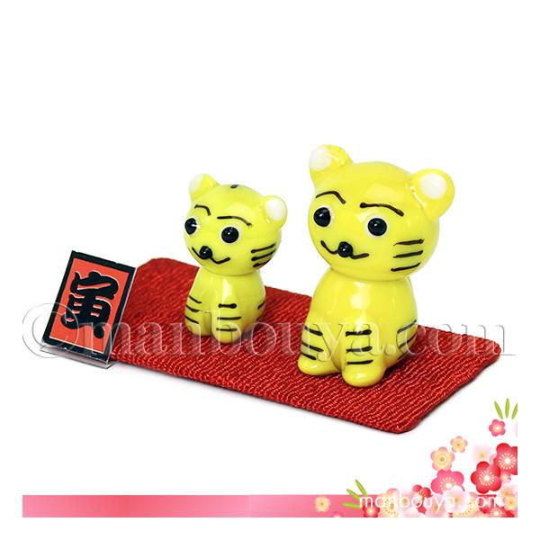 干支とらのガラス製置物。赤いちりめん素材の布台と立て札、親子ペアのガラス細工がセットになっています。場所を選ばず飾れる、かわいいミニサイズ。オフィスのデスクにちょこんと置いても目を引きそうです。【サイズ】布台：約4.5×2.4cm（商品によ...