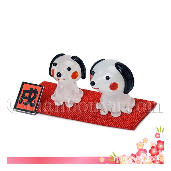 干支いぬのガラス製置物。赤いちりめん素材の布台と立て札、親子ペアのガラス細工がセットになっています。場所を選ばず飾れる、かわいいミニサイズ。オフィスのデスクにちょこんと置いても目を引きそうです。【サイズ】布台：約4.5×2.4cm（商品によ...