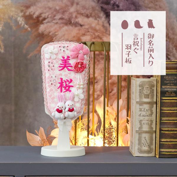 商品番号：HGI-7671-01種類：とってもコンパクト 豆羽子板商品名：刺しゅう お名前入り 羽子板 桜羽うさぎ つまみ細工 白塗り 飾り台セットサイズ：間口11×奥行10×高さ26cm【ご注意ください】※生地の模様の出かたが異なる場合が...