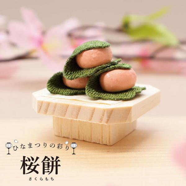 小さなお雛さまと一緒に飾りたい、ミニチュアサイズの雛飾りです。ちりめんの風合いがとてもかわいい、手作りの桜餅です。台は木製です。展開例を参考に。別売り：ぼんぼり/三色団子/桜と橘/三色団子/塗台小黒サイズ：(横幅×奥行×高さ) 約3.5cm...