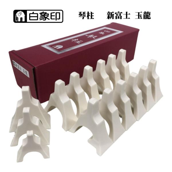13弦お箏用　琴柱白象　新富士（玉龍）琴柱の定番、白象の琴柱です。本商品は定番の白龍シリーズより高重量タイプで白龍の約1.35倍の重さの琴柱です。玉龍は白龍と同じく足の形が異なる3種類からなります。本商品はその中で足幅(足の厚み)が最も広い...