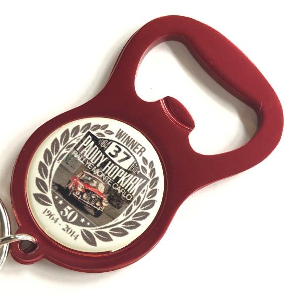1964年にドライバー：パディ・ホプカークにより初の総合優勝となったモンテカルロラリーから50周年を記念したメモリアルグッズです。クラシックミニのラリースタイルが好きな方におすすめです。ボトルオープナー付きキーリング6cm×4cmBottl...