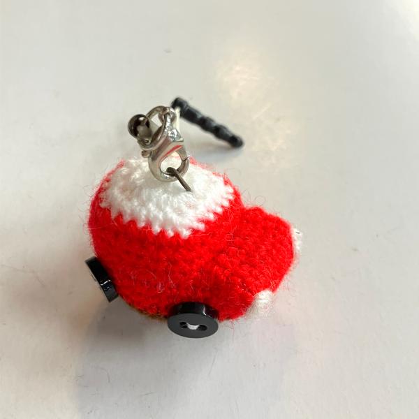 スマホや携帯電話のイヤホンジャックに差し込むアクセサリーです。赤いクラシックミニのチャームがついています。サイズは約3.5cmx3cmx2.5cm