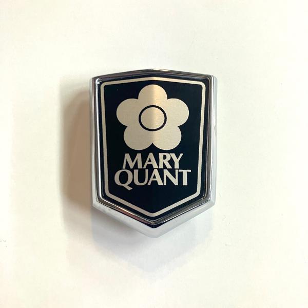 限定車であるクラシックミニのマリークワントのフロントボンネット用エンブレムです。新品ですが、写真の物が現品です。5.3cm×6.8cmローバーミニ用MK3タイプのボンネットバッヂです。取り付けはMK3純正と同じ3本の爪で差込式となっておりま...