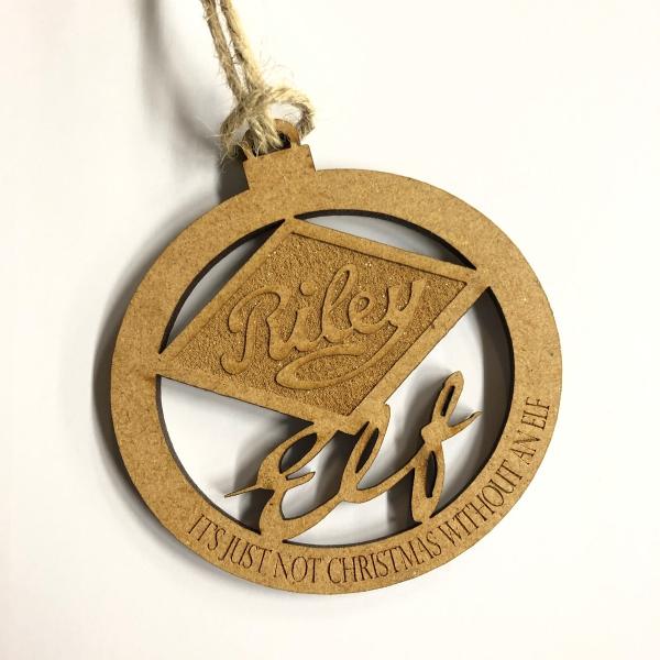 ライレーエルフの木でできたハンドメイドのオーナメント。ラメ付でキラキラ光ります。車内に飾るもよし、ガレージや家の中に飾るも良し、お好きな場所に飾ってください。写真のものが現品です。直径：7.7cmRiley Elf Christmas Tr...