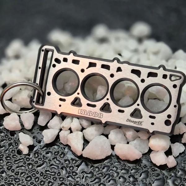 フォルクスワーゲン アウディ VAG1.8/2.0TFSI/TSエンジン（EA888）用シリンダーヘッドガスケットを精密に再現したミニチュアキーチェーン。厚さ2mmのステンレスに職人の手でブラッシュ仕上げを施した、ドイツ製のこだわりの逸品。...