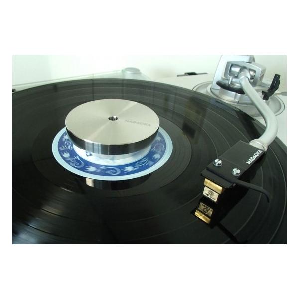 比重の高いステンレス材を用いて、レコード盤をターンテーブルに密着させ、機械的共振を抑えます。溝のトレースが正確になり再生音のクリア感、解像度が向上します。レコード盤上に「のせる・外す」を繰り返すため、落下しないようデザイン検討した結果、レコ...