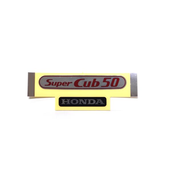 スーパーカブ50ファイナルエディションのボディカバーに用いられているステッカーです。丁度、シートの下あたりの位置で、左右に貼付されています。※ホンダ純正部品※1枚の価格です※1台分をご要望の場合は、数量「2」でご注文下さい。※貼り付け面をよ...