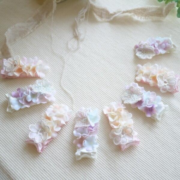 世界のハイブランドでも使用されている木馬リボンのベビーヘアアクセサリー。艶やかリボンに小花の花びらをのせました。ベビーからキッズも使えるクリップパット付きヘアクリップ。ピンの長さ：５ｃｍ全長：５ｃｍＭＯＫＵＢＡのフリルサテンリボンでお作りし...