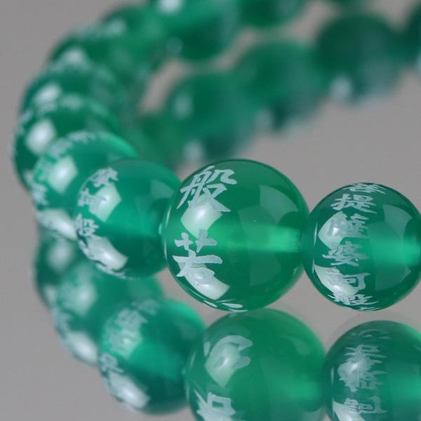 仏の教え、般若心経の真髄を彫刻した数珠ブレスレットでございます。素材は、緑瑪瑙でございます。鮮やかな色合いが印象的でございますので、お手元のワンポイントにも、最適でございます。親玉と天玉を除く一玉一玉にお経の一説が彫られており、ブレスレット...