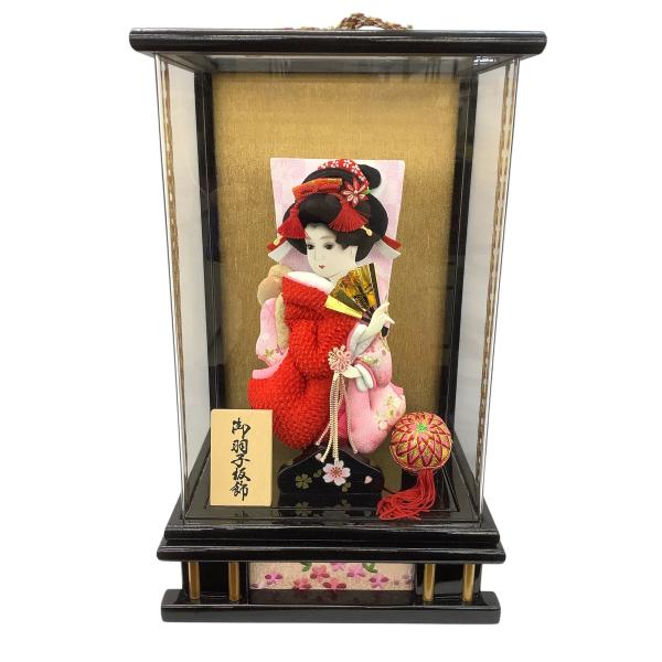 「鹿の子 金彩 凛」8号の羽子板ケース飾りです。美しい日本髪に華やかな髪飾りをあしらい、扇を手にした女性の姿を立体的に仕立てた、趣のある羽子板です。衣装には鹿の子模様が取り入れられ、金彩や花柄などの細やかな装飾が施されています。足元には手毬...