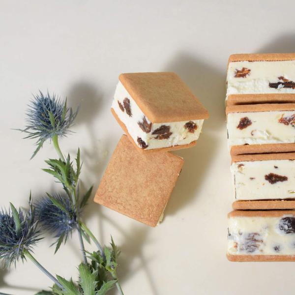 バターサンドの定番フレーバー、ラムレーズン香る「TABLES 堀江バターサンド レーズンバター」です。ラム酒に漬け込んだレーズンを甘過ぎず軽いバタークリームに混ぜ込みました。そのバタークリームを、最高級品のスペイン産マルコナアーモンドのアー...