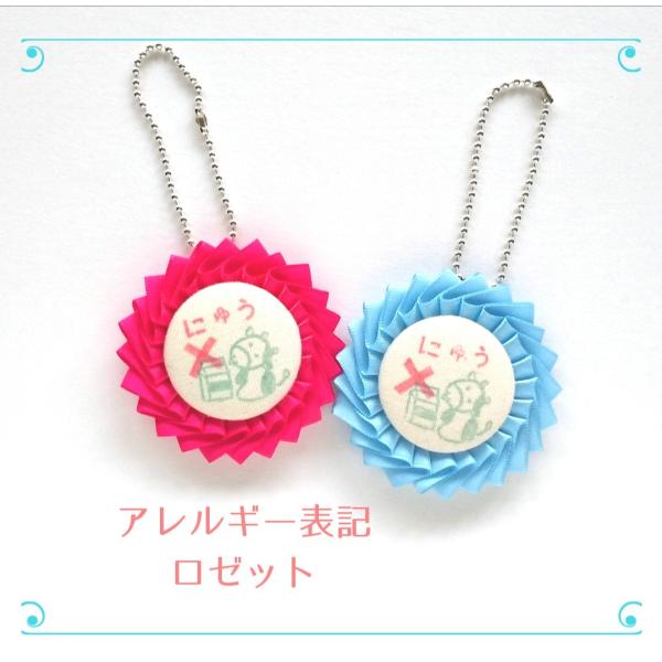 ちびすけオリジナル・食物アレルギー表記のロゼットです。(乳製品)自身で伝えることができないお子さまを守ってくれるかわいいマーク！バッグなどに付けられます。各一点限定。【サイズ】マーク部分 直径約4cm全体 直径約6.5cm【ご注意ください】...