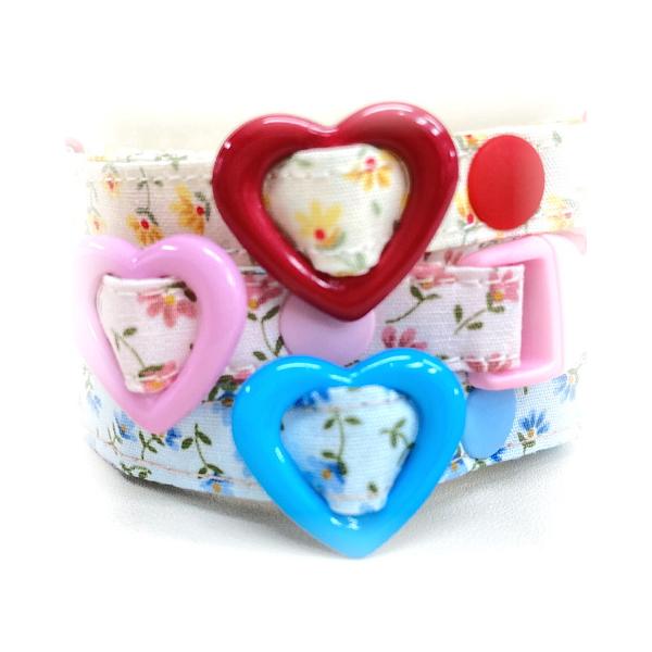 手作りの首輪です。小さな花の柄の生地を使用して可愛く首輪に仕上げました。３色ございます。留め金は、一定の力の付加で外れる安全バックルです。猫がずっと装着しても、首輪下の毛に負担がかからないように生地を重ね縫いしているのみで、中に芯などは入れ...