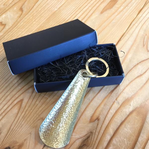 東京の下町に残る金属加工職人の手により、金属の美しい輝きを生み出す細かい凹凸の彫金が施された真鍮の靴べらです。色は真鍮の色合いを活かしたゴールドと、ニッケルメッキを施したシルバー、銅メッキ・ダールブラックメッキを施したブラックの3色展開にな...